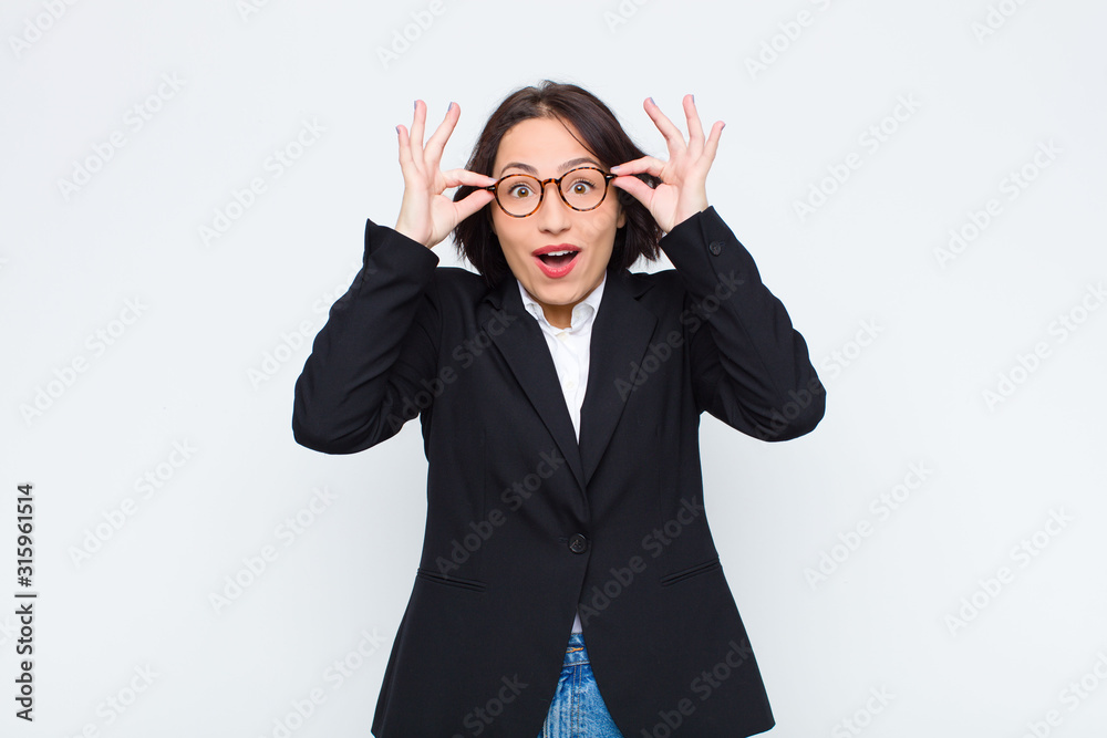 young businesswoman feeling shocked, amazed and surprised, holding ...