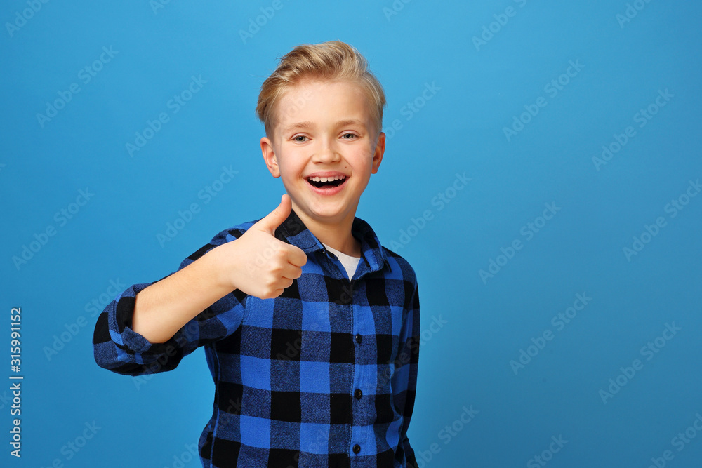 OK cheerful boy shows thumbs hand. Happy, smiling boy on a blue ...