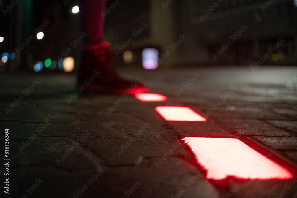 girl's feet in boots are standing on a pedestrian crossing and waiting ...