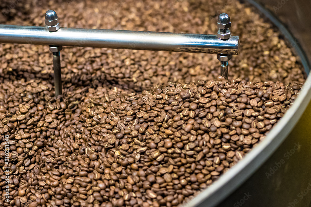Fresh roasted coffee arabica beans have been cooled down in the roaster ...