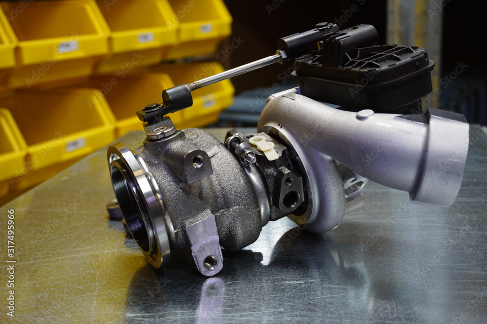 Modern turbocharger on a steel background. Turbocharger element allows ...