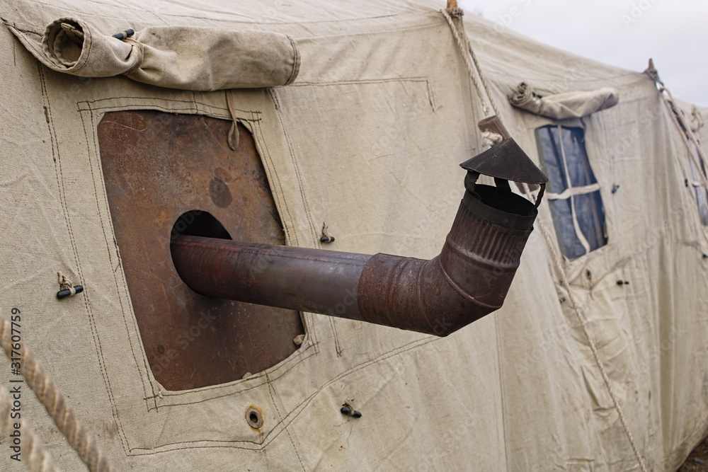 Black rusty metal pipe of a wood burning stove in the window of a ...