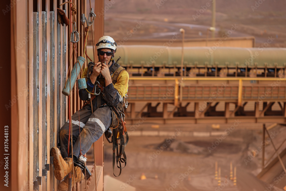 Rope access hard worker welder wearing fully safety body harness ...