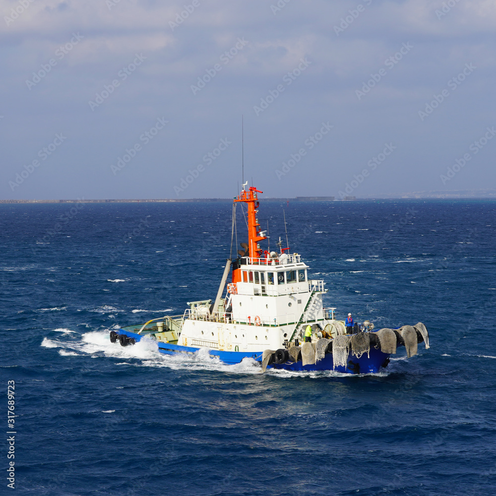 bright sea tug in the port of the Japanese city of Naha. Powerful ...