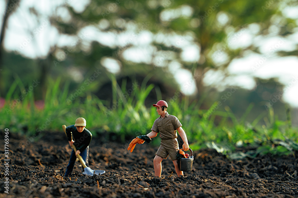 Miniature farmer is digging the soil to plant trees Taking care of ...