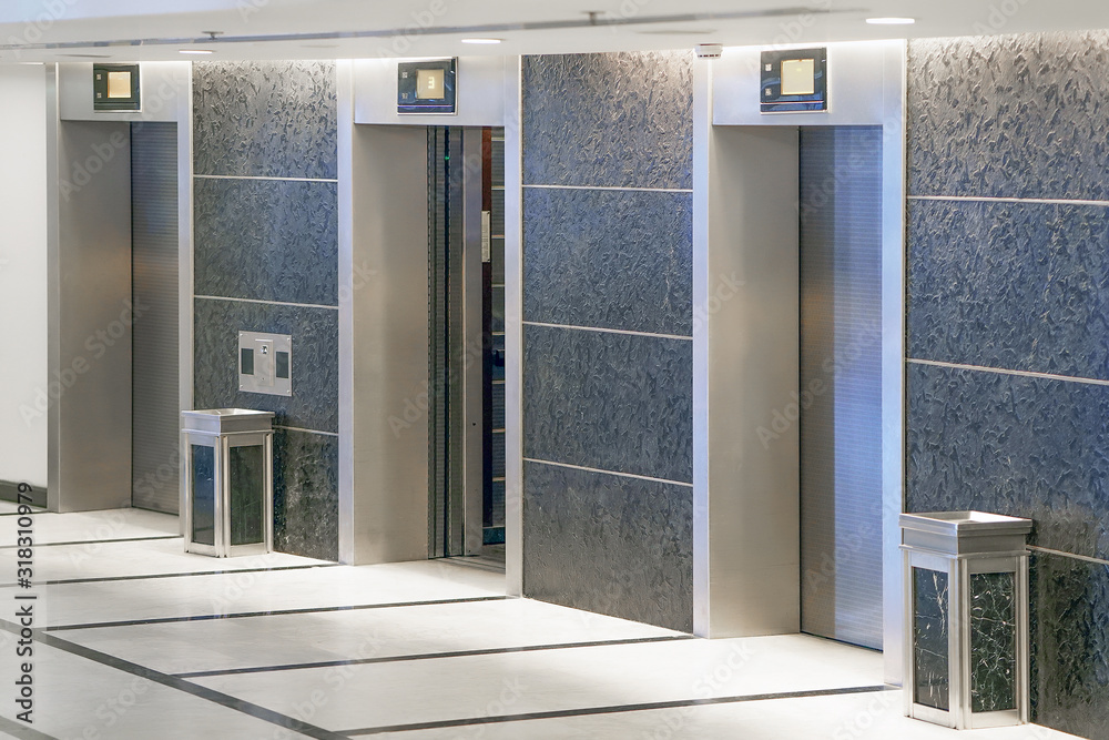 ภาพถ่าย Stock Three elevator doors in office building. Wide angle view ...
