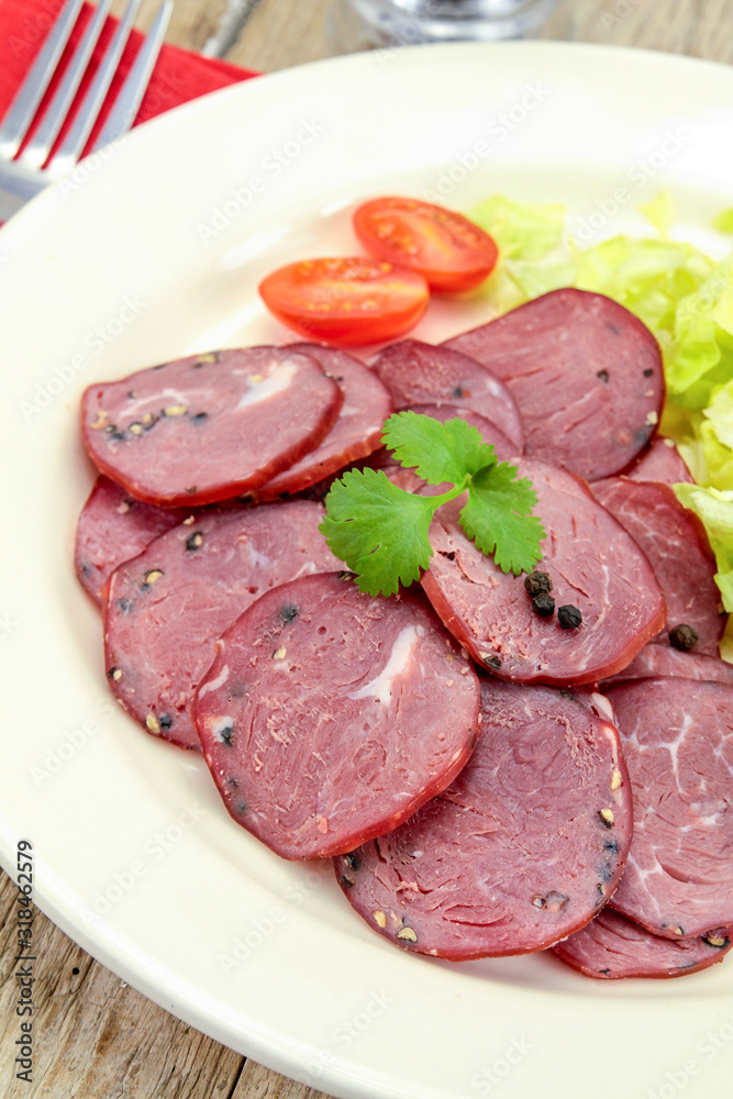 tranches de saucisson au poivre dans une assiette Stock Photo | Adobe Stock