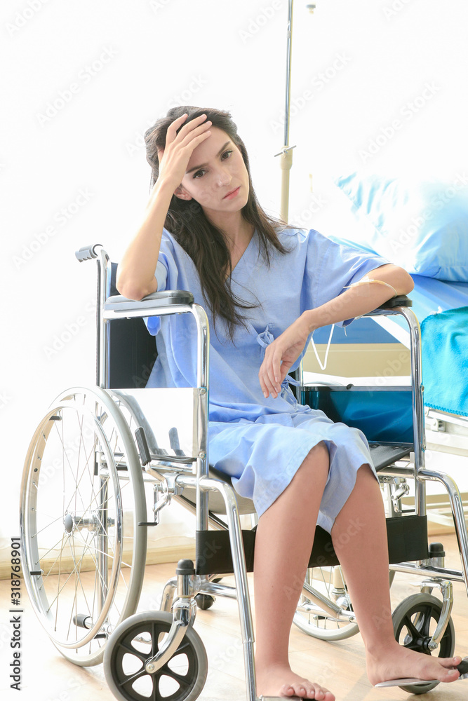 Sick girl sitting in wheelchair in the hospital room. Disabled woman ...