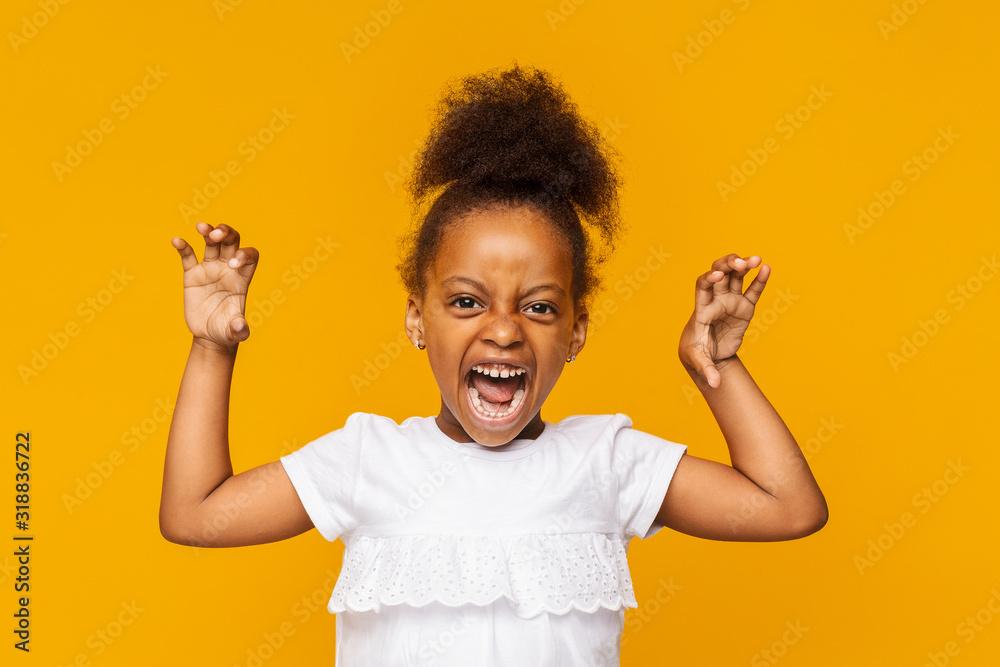 Funny afro little girl imitating tiger over yellow background Stock ...