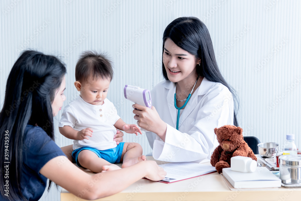 Asian female doctor using infrared fever measuring device With a 1 year ...