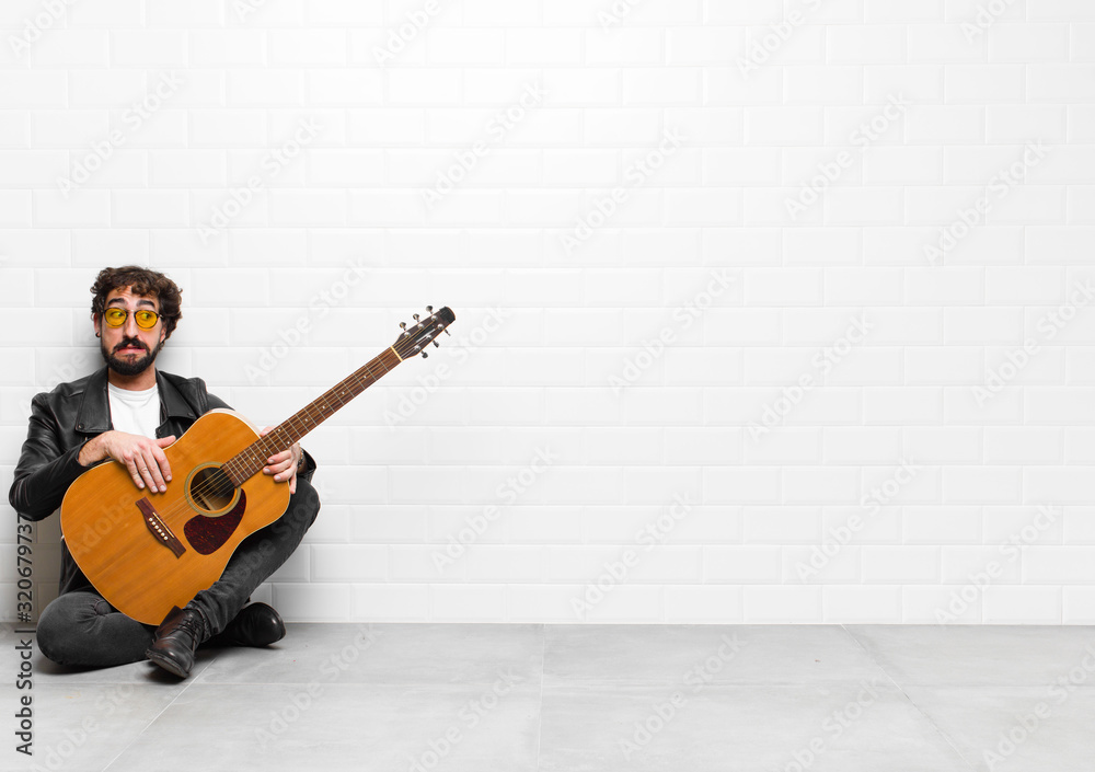 young musician man looking worried, stressed, anxious and scared ...