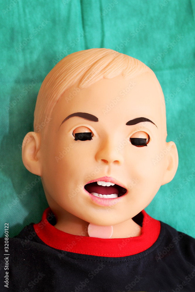 The head of a lying training dummy imitating a small child with an open ...