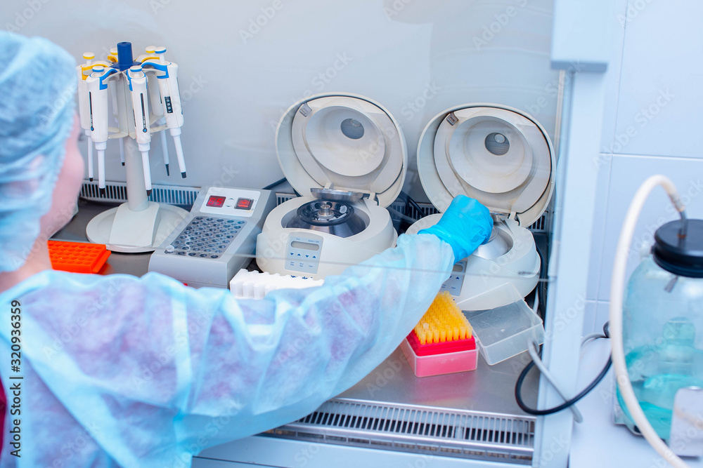 Dna test in the lab. a laboratory technician with a dispenser in his ...