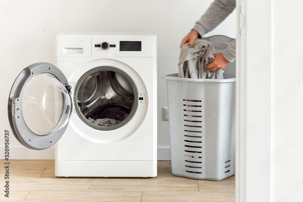 Side view putting clothes in washing machine in the home laundry Stock ...