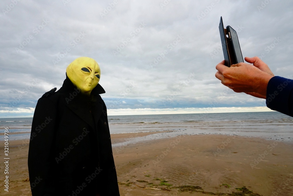 Alien in black clothes on a mysterious background and another person ...