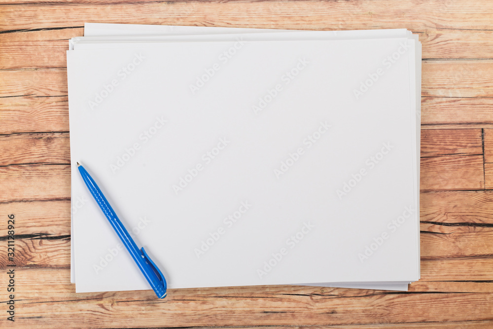 A4 white paper with pen on wooden background. Blank branding template ...
