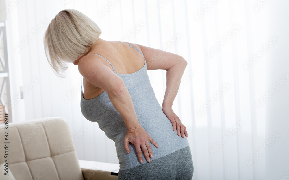 Middle aged woman with pain in the backache and lower back. Concept ...