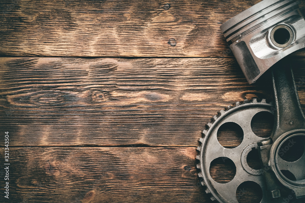 Old car engine piston with connecting rod and cog wheel on wooden ...