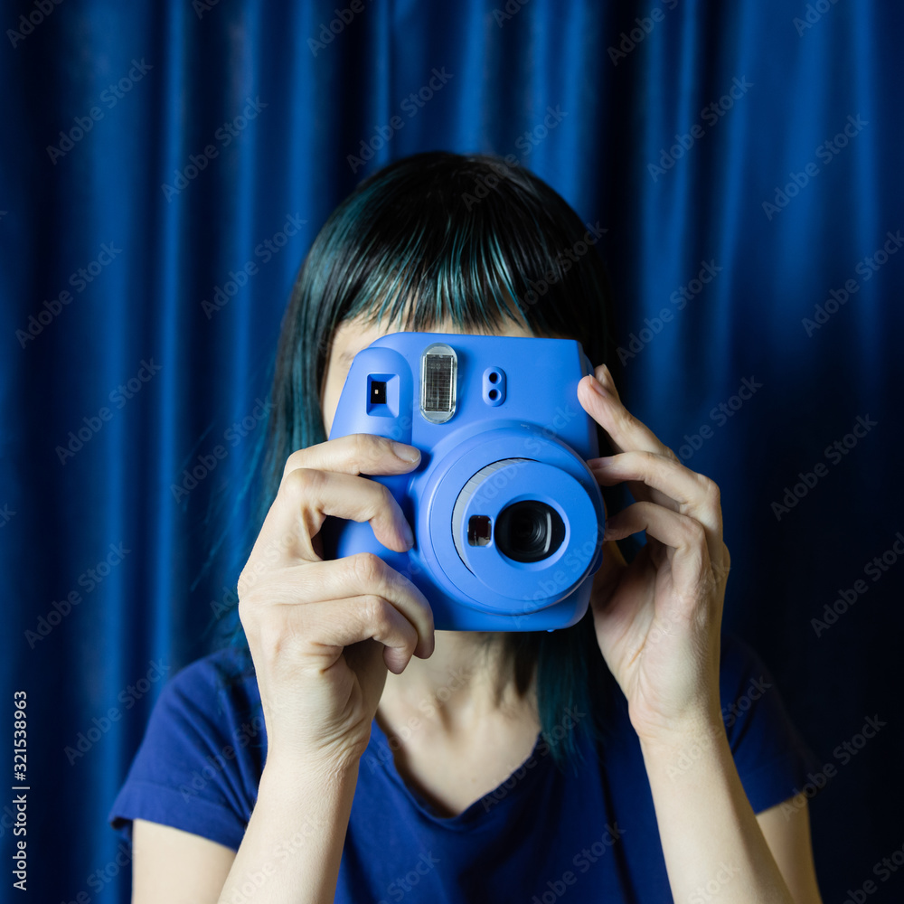 Concept of Faceless girl with a blue camera. Portrait of a woman ...