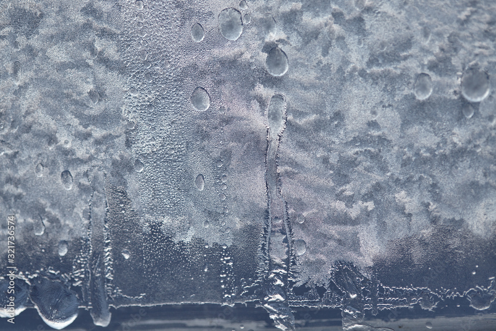 Frozen drops of condensed steam water drops on the transparent window ...