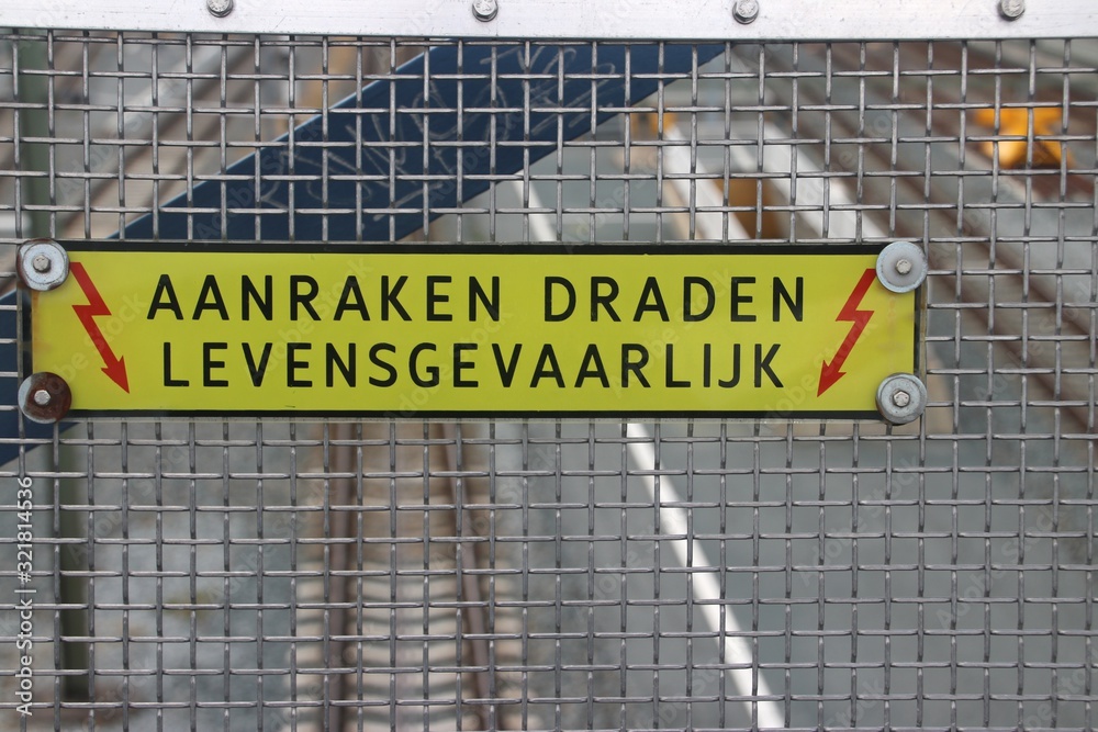 Warning sign with dutch text "aanrakeen draden levensgevaarlijk; which ...