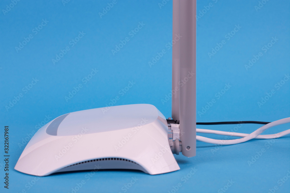White wi-fi router on a blue background. Side view. Free space for an ...