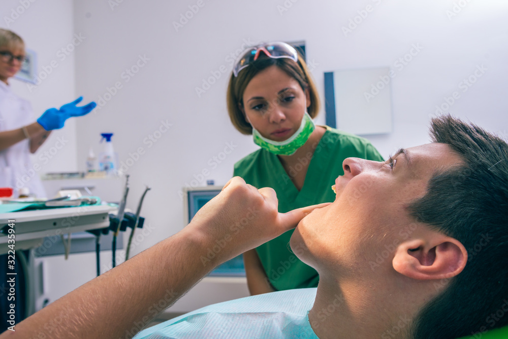 Closeup image of a teenage boy patient showing his toothache to his ...