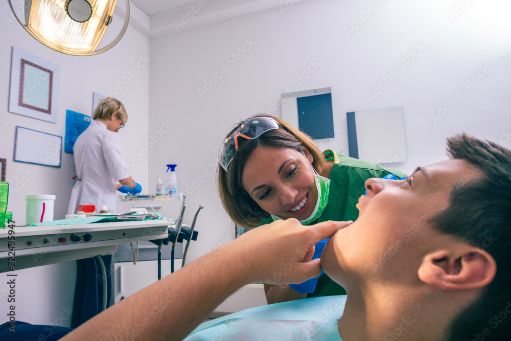 Closeup image of a teenage boy patient showing his toothache to his ...