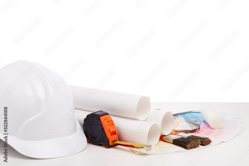 Architectural blueprints, hard hat, color palette guide, tools on white ...