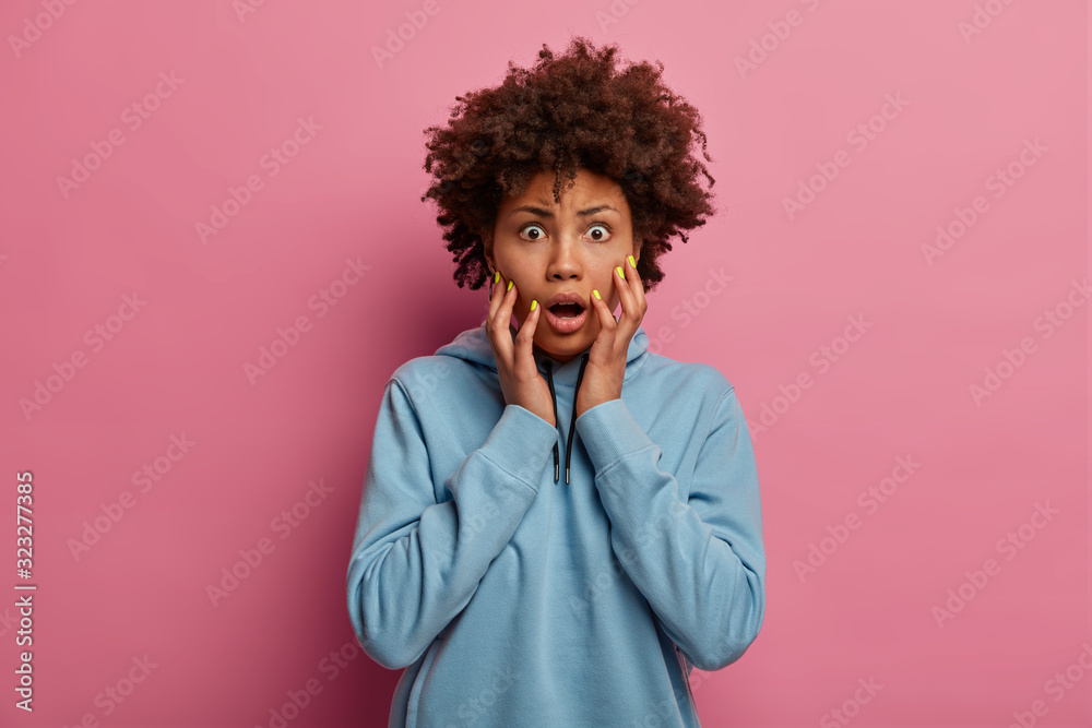 Стоковое фото «Scared shocked Afro American woman stares with wide ...