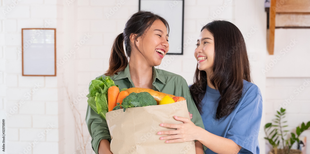 Happy asian couple lesbian holding vegetable bag looing at camera after ...