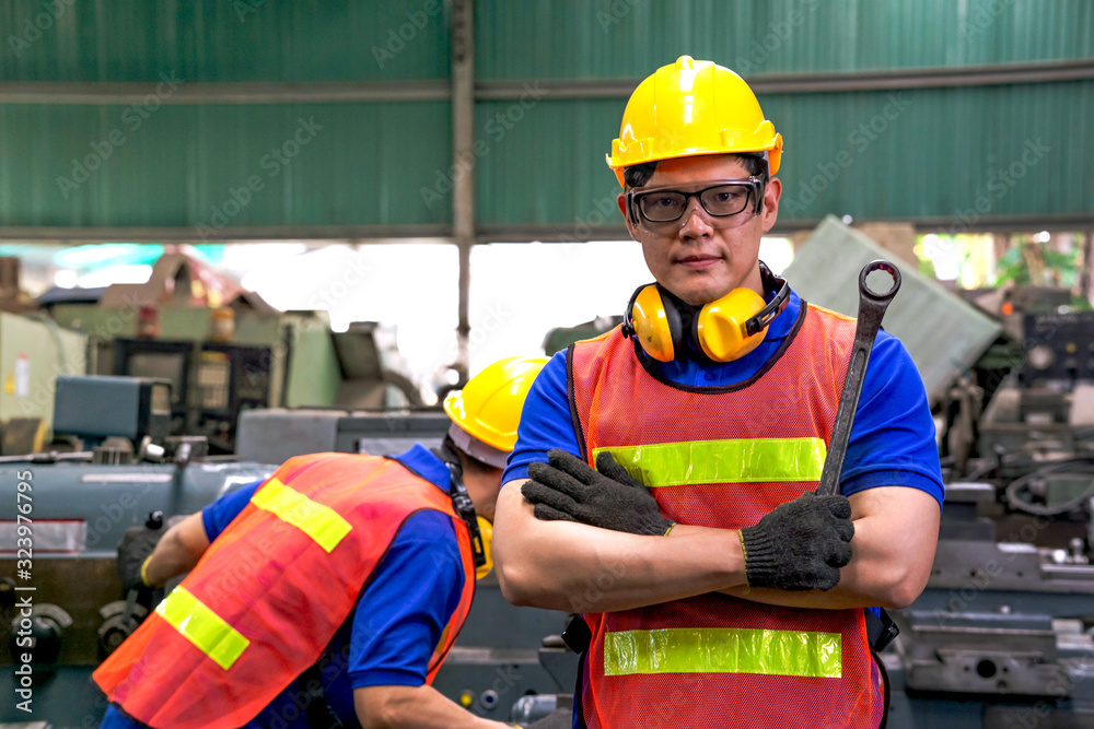 Portrait of a mechanical engineer or worker with yellow safety helmet ...