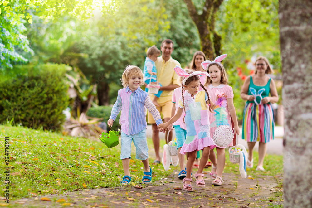 Family with kids on Easter egg hunt Stock Photo | Adobe Stock