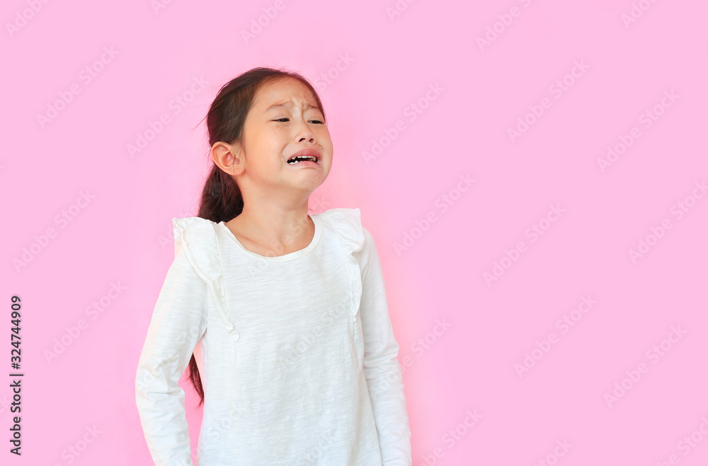 Asian little child girl crying with copy space isolated on pink ...