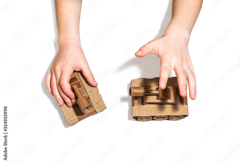 children's hands play with tanks. two toy tanks made by children from ...