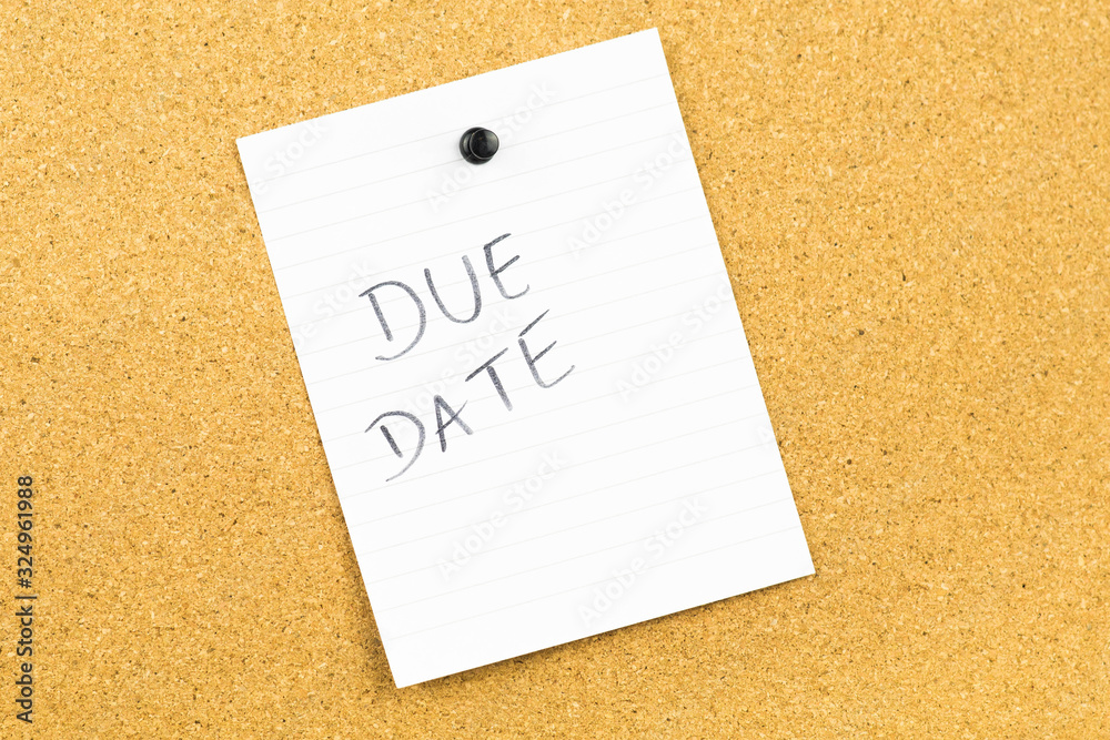 white sticky note with Due Date text on cork board. Birth date, third ...