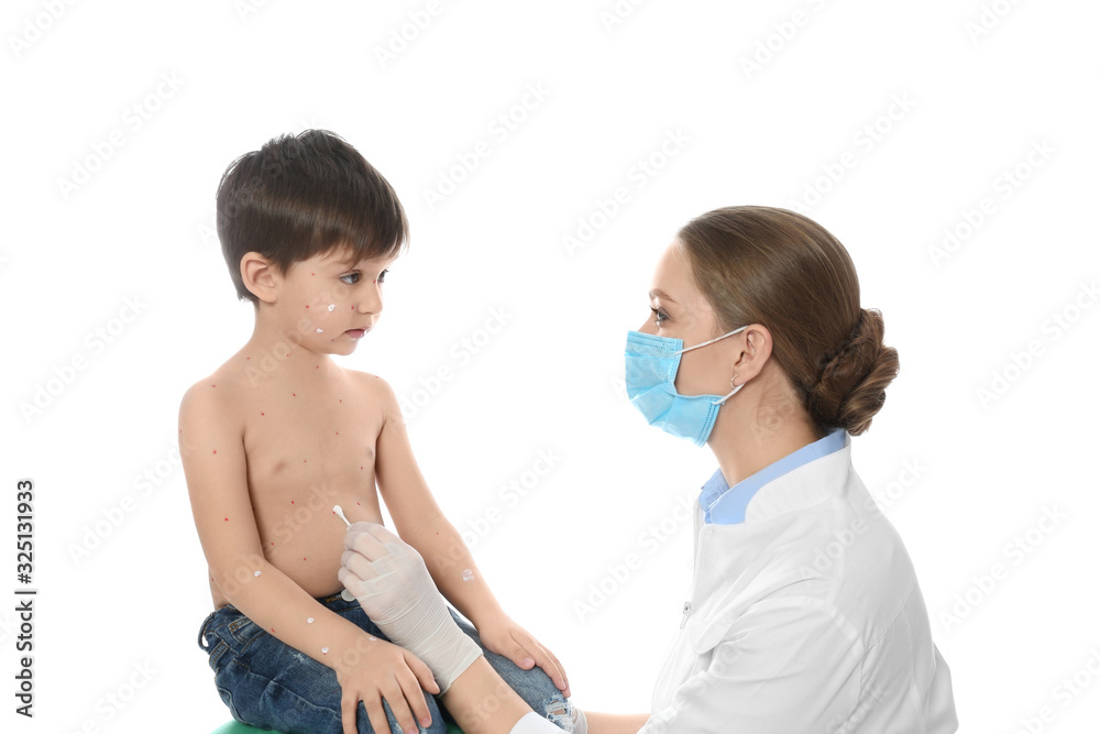Doctor applying cream onto skin of little boy with chickenpox against ...