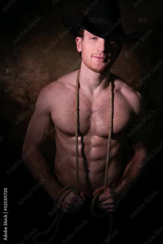 Handsome cowboy wearing a hat with barechest showing defined pecs and ...