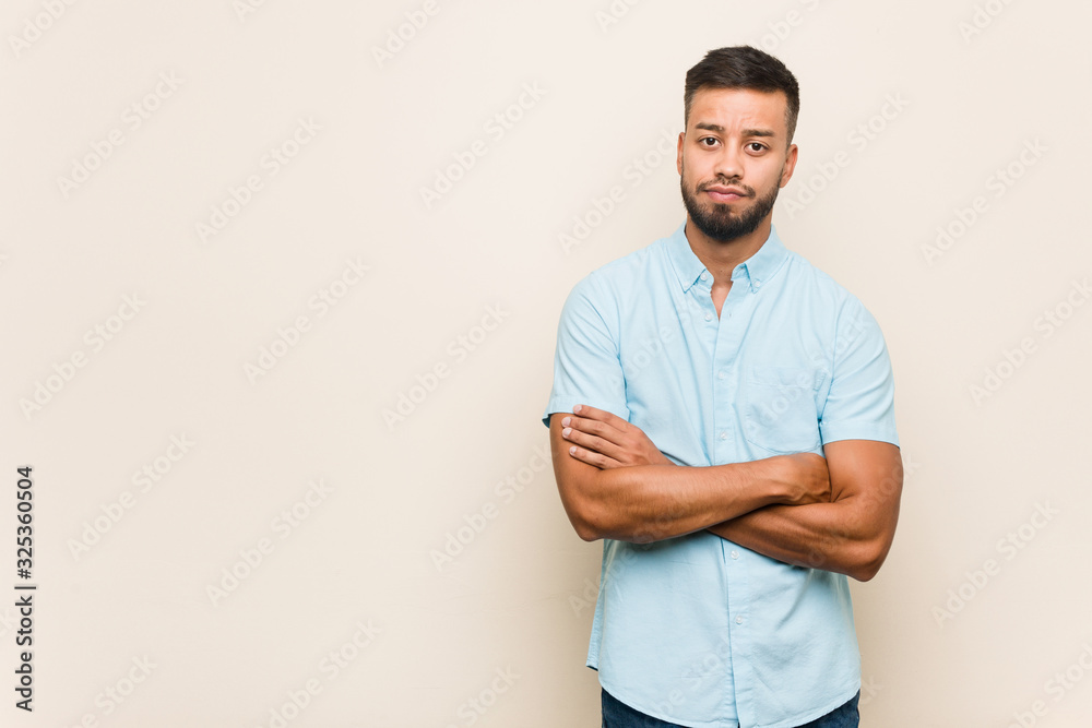 Young south-asian man unhappy looking in camera with sarcastic ...