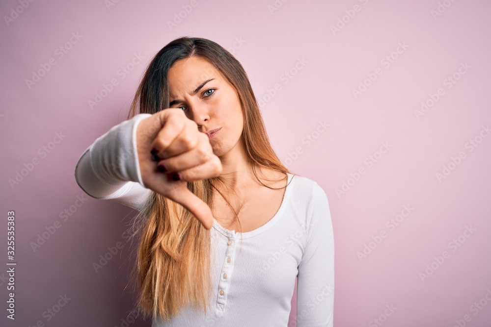 Young beautiful blonde woman with blue eyes wearing white t-shirt over ...