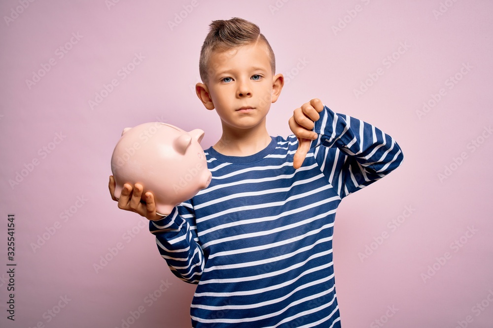 Young little caucasian kid banking money on piggy bank as wealth ...
