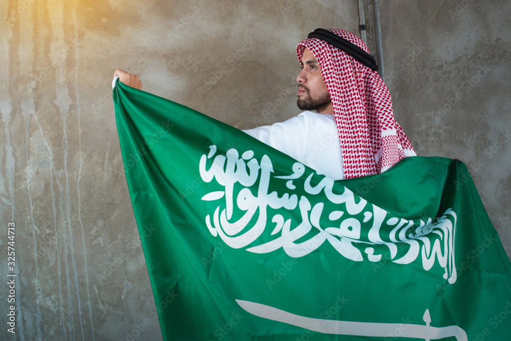 Saudi Arabia man holding flag, Arabic letters mean ”There is no god but ...