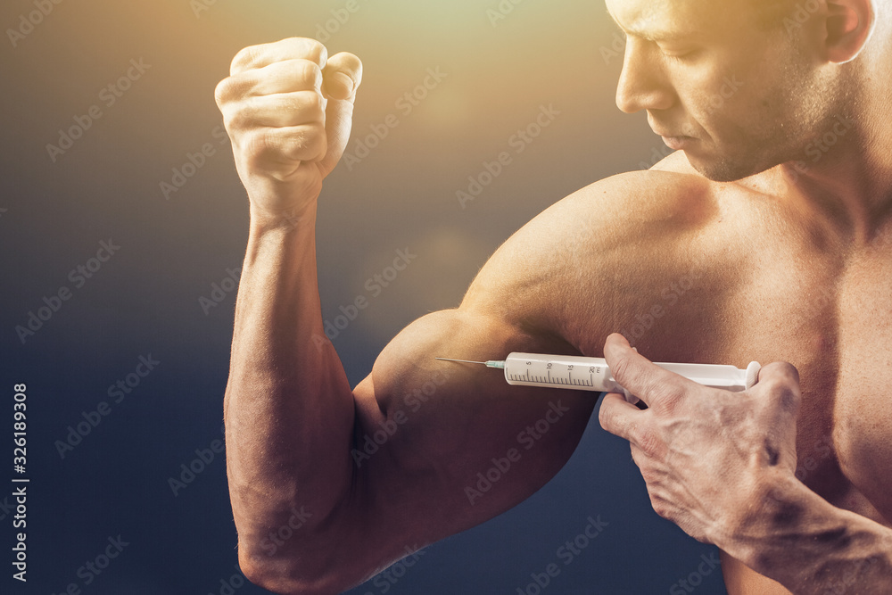Bodybuilder makes injection of vitamins. Photo of sporty man with ...