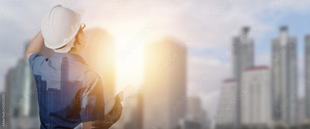 engineer holding blueprint with construction building background ...