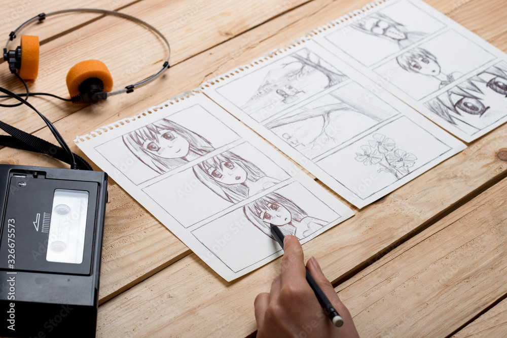 Artist drawing an anime comic book in a studio. Stock Photo | Adobe Stock