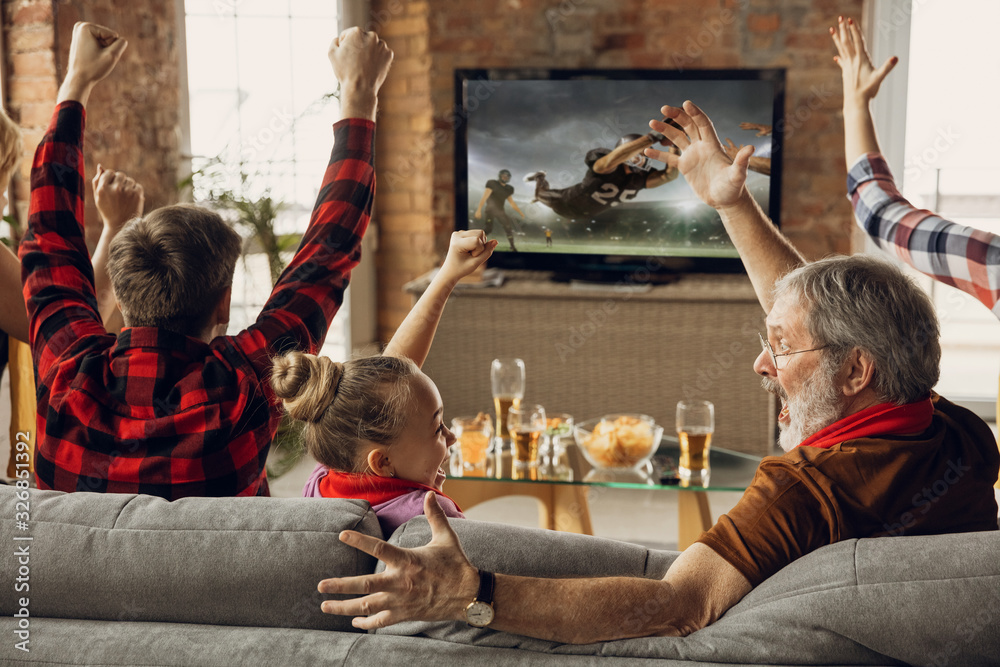 Victory. Excited, happy family watching american football match ...
