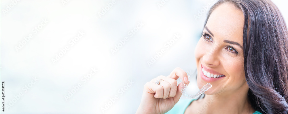 Invisalign orthodontics concept - Young attractive woman holding ...