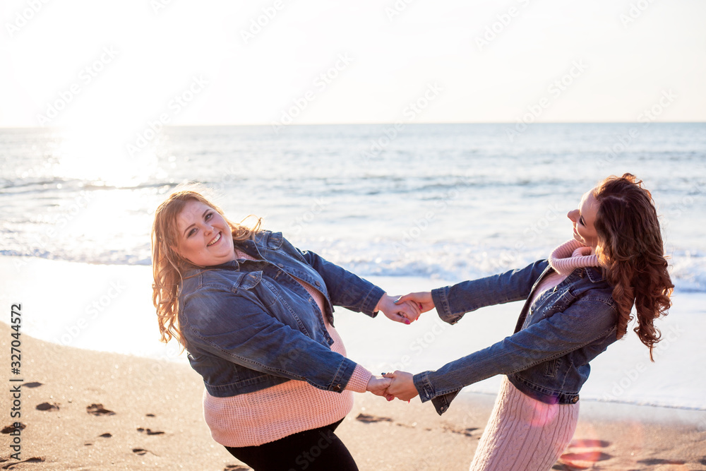 Back view of two freinds , plus size with thin girls walking on the ...
