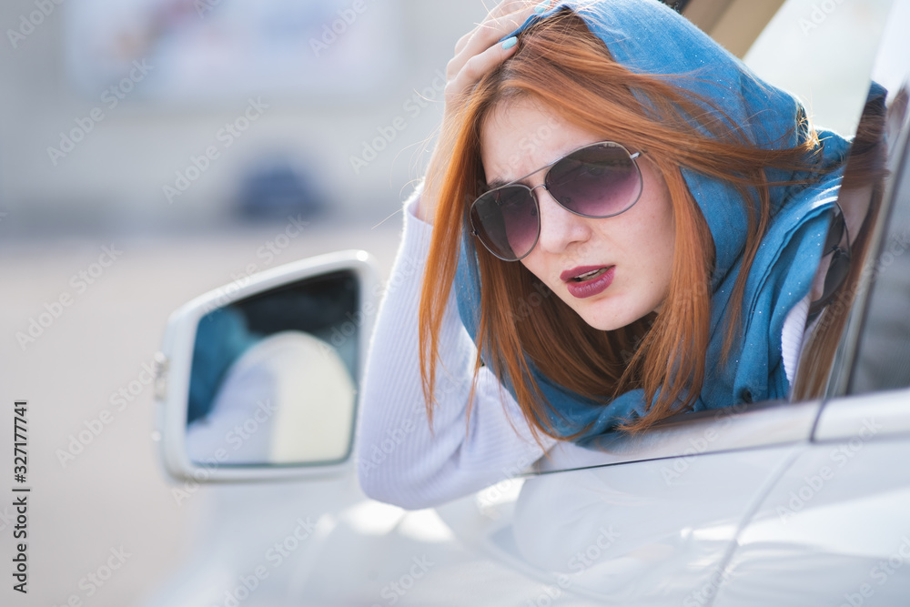 Young woman driving a car backwards. Girl with funny expression on her ...
