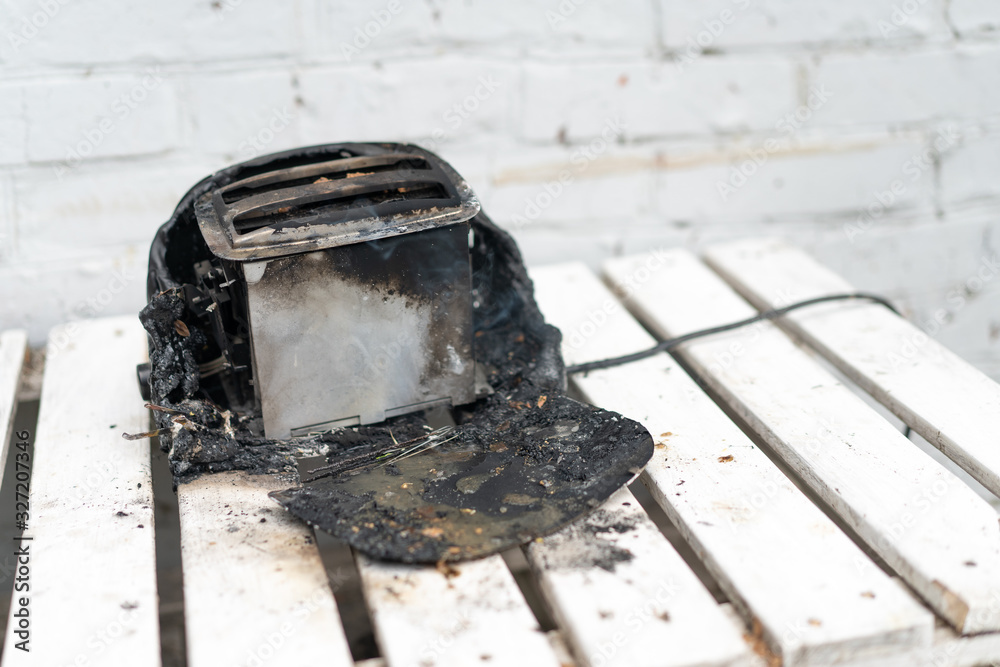 Burning toaster. Toaster with two slices of toast caught on fire over ...